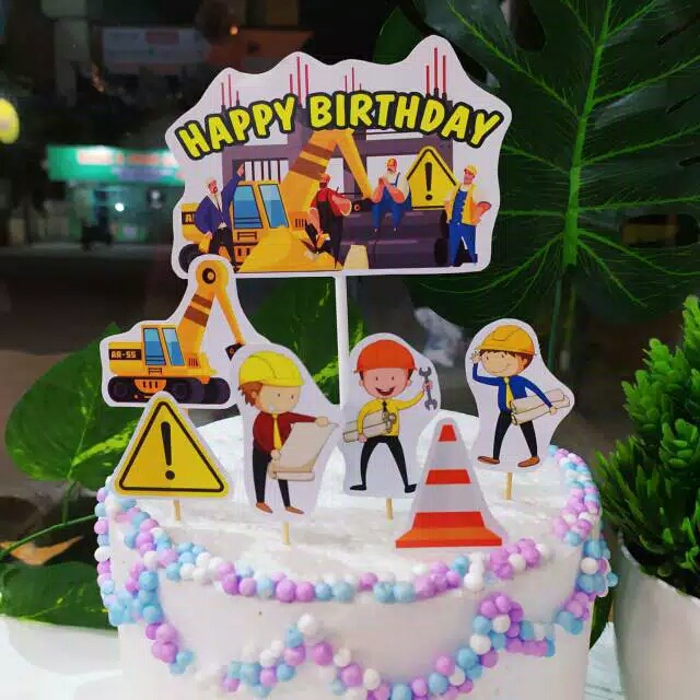 A set of birthday cake topper decorations with construction motifs ...