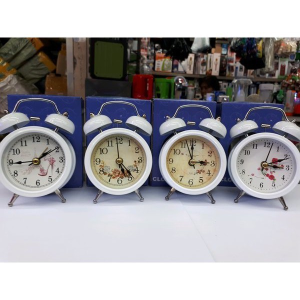 PUTIH The white round ring alarm clock has a picture. The weker makes a ...
