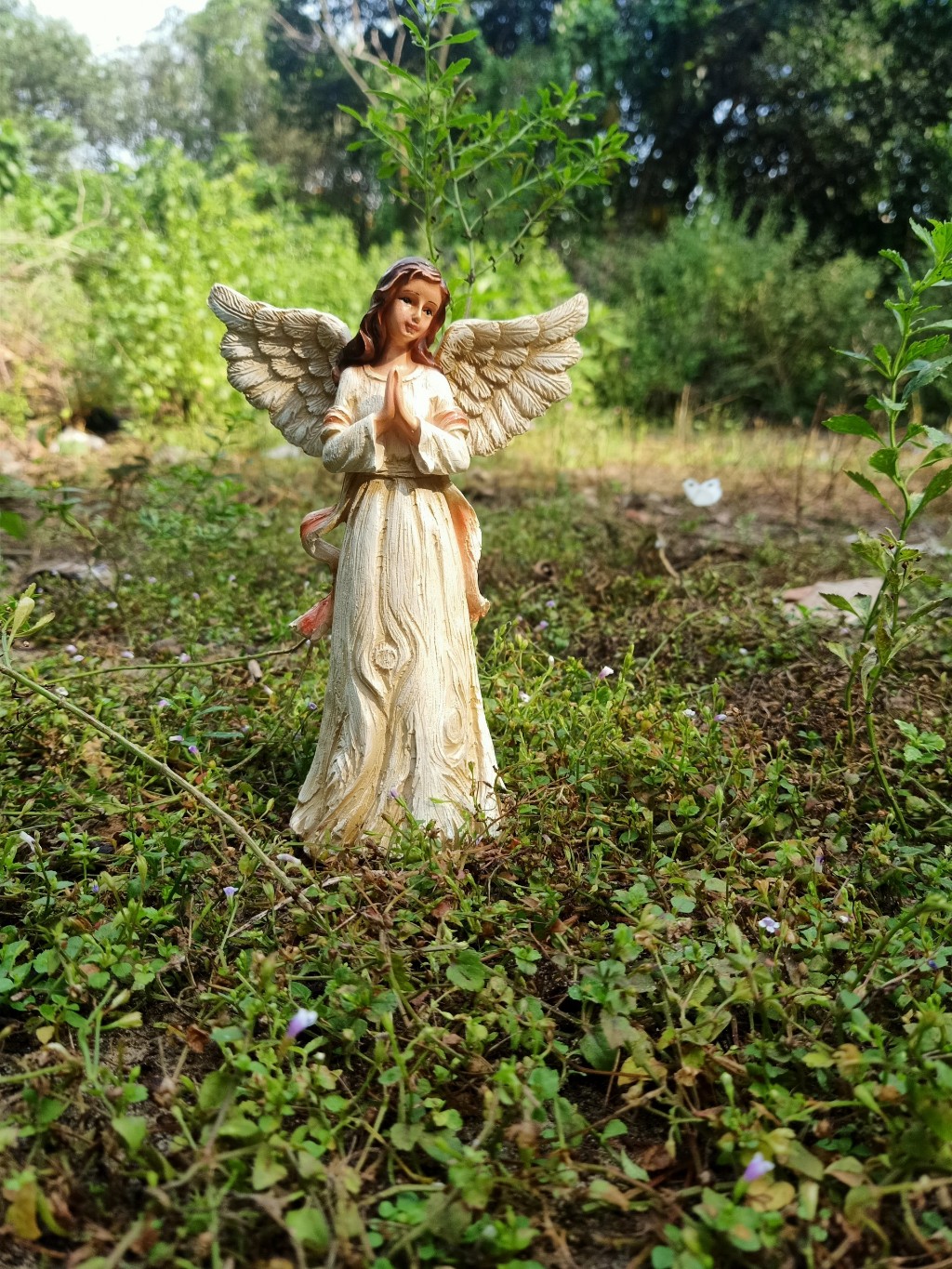 Statue of Angel falling into a tree. Angel decorates the living room ...