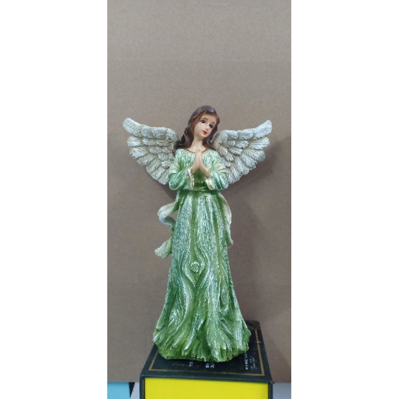 Statue of Angel falling into a tree. Angel decorates the living room ...